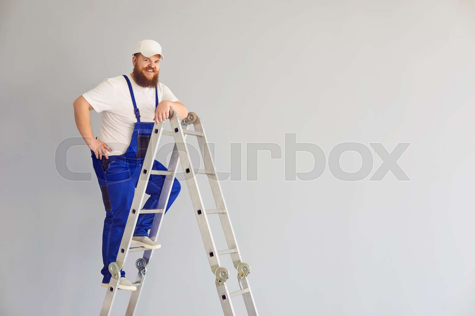 Builder funny man worker.Delighted male constructor on metal ladder ...