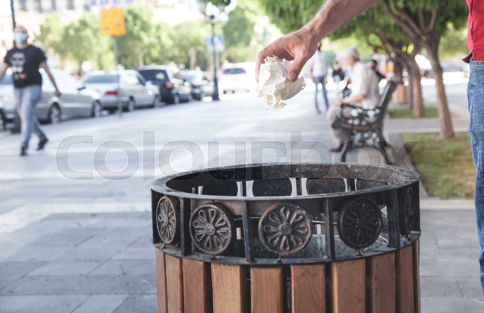 Man throwing garbage in a trash bin. | Stock image | Colourbox