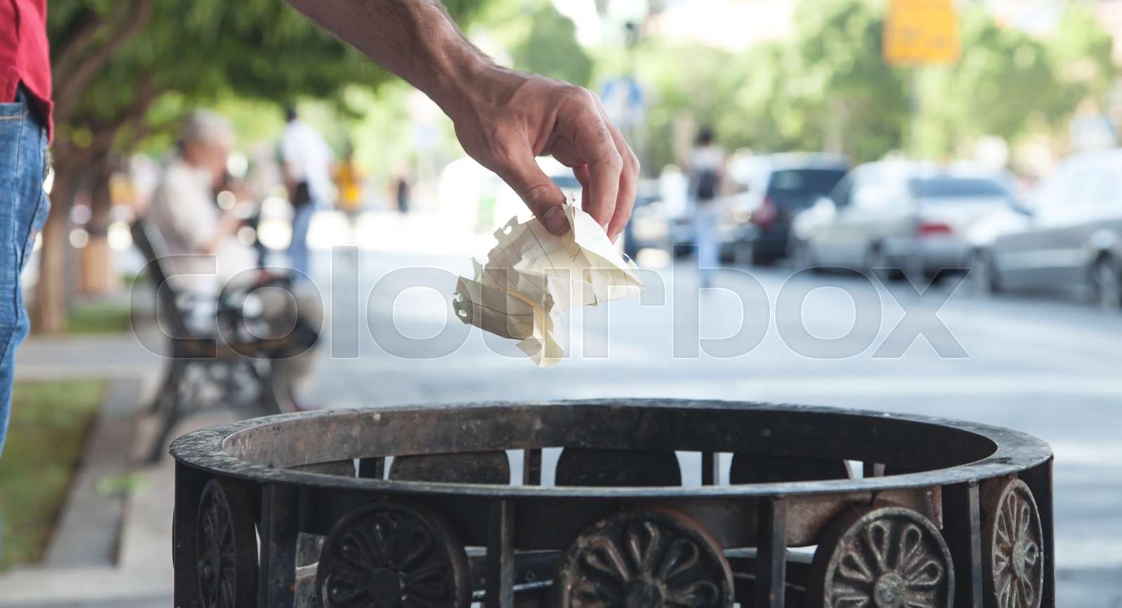 Man throwing garbage in a trash bin. | Stock image | Colourbox