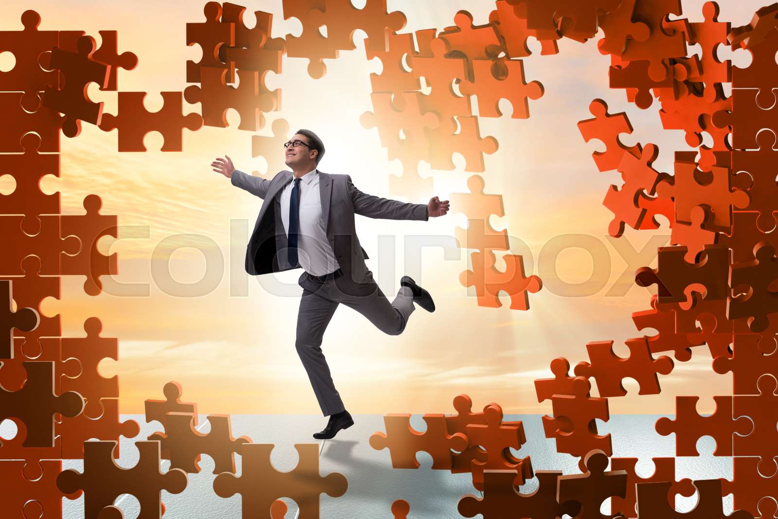 Businessman breaking the wall of jigsaw puzzle | Stock image | Colourbox