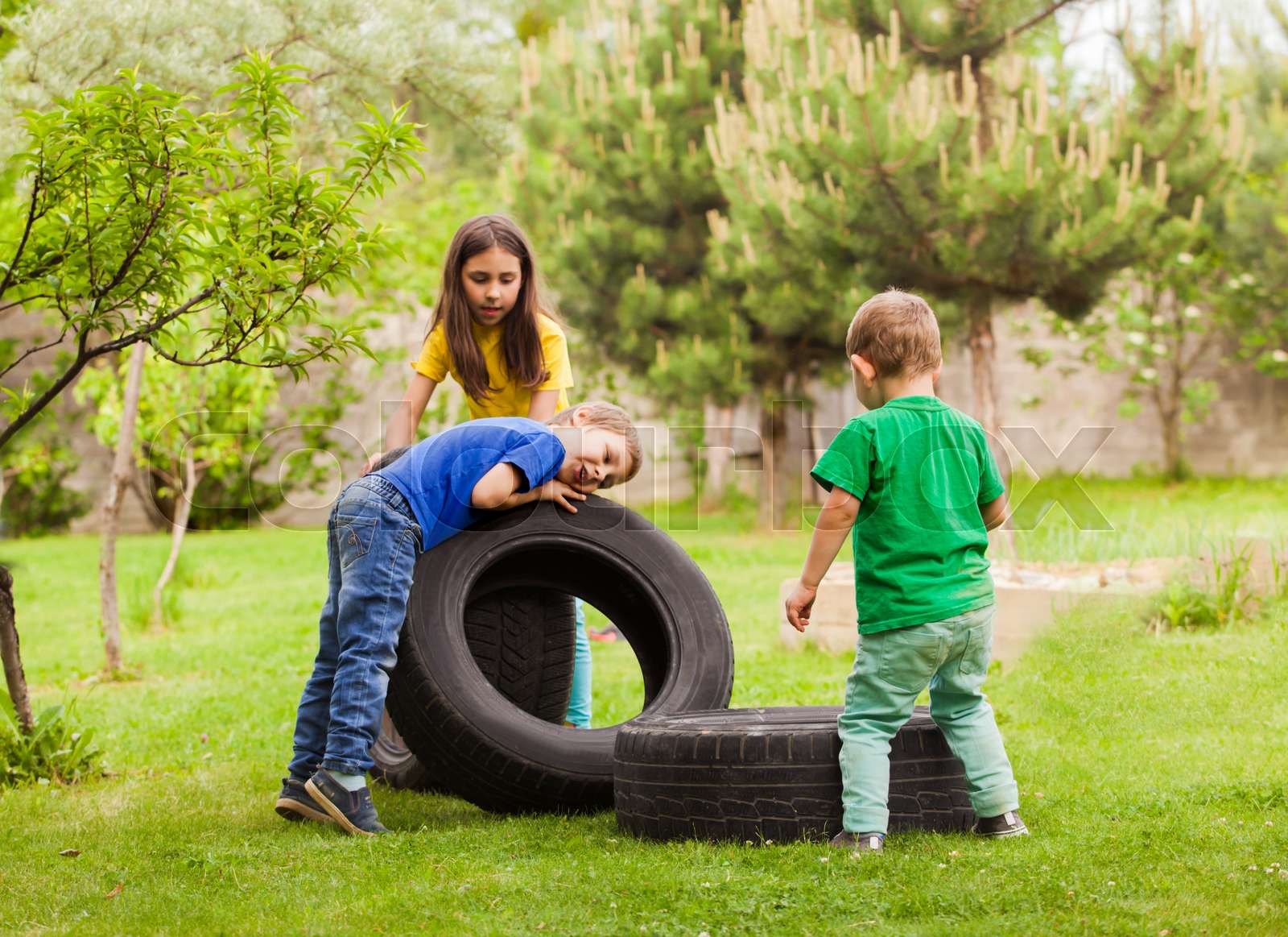 The little children help to move car tires | Stock image | Colourbox