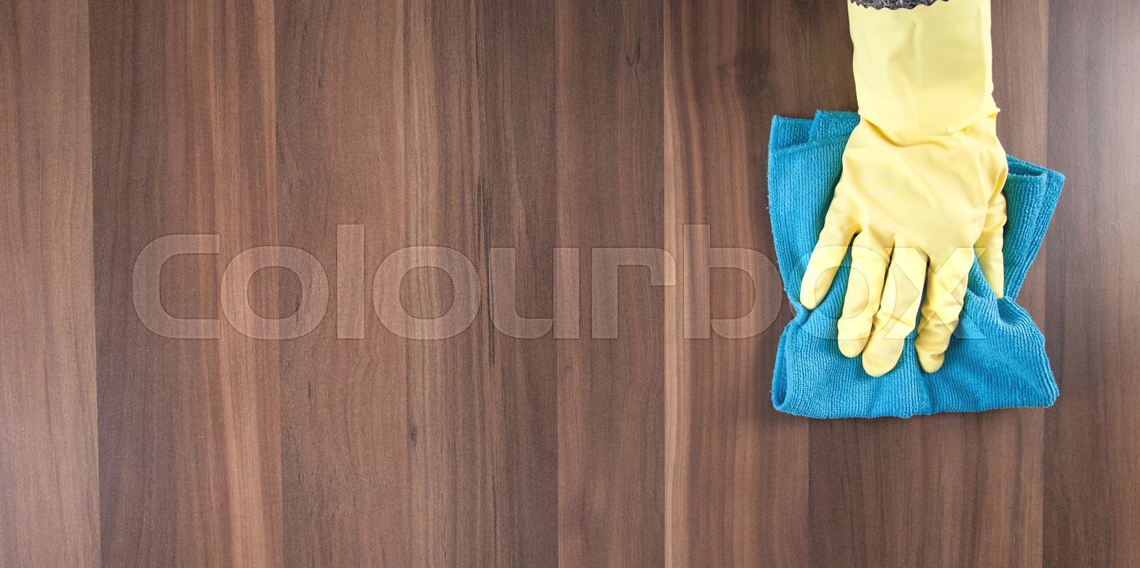 Hand cleaning wooden table at home. | Stock image | Colourbox