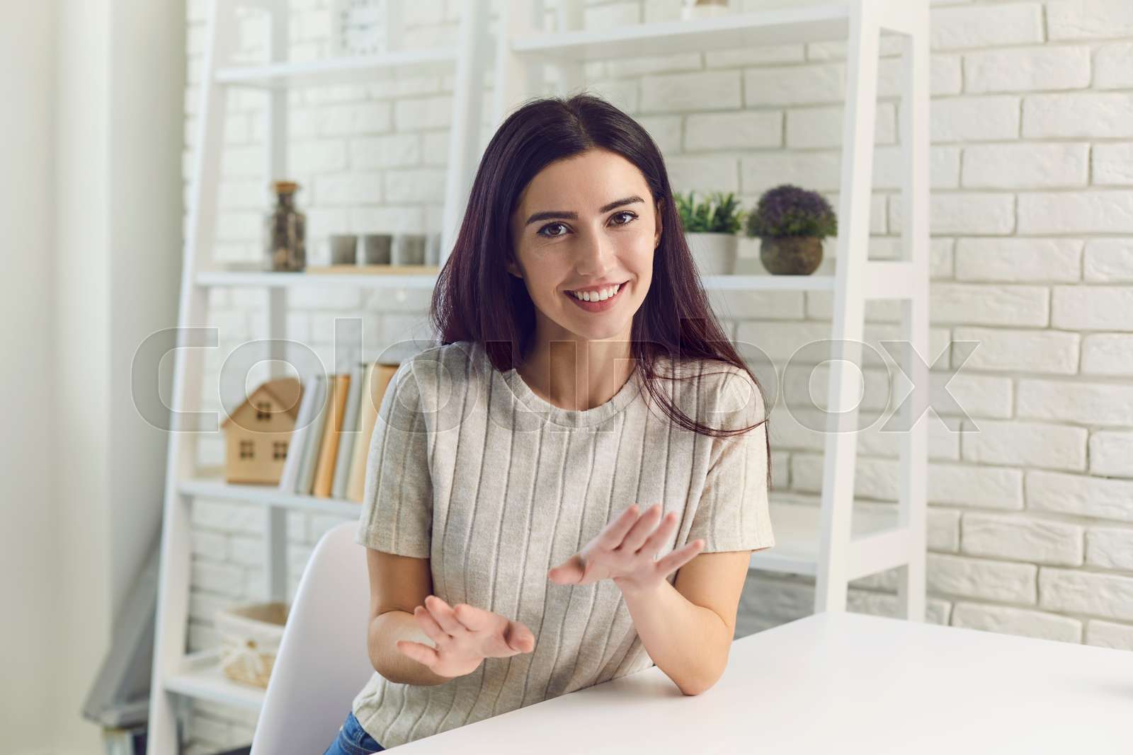 Young girl communicating online or participating in looking at camera ...