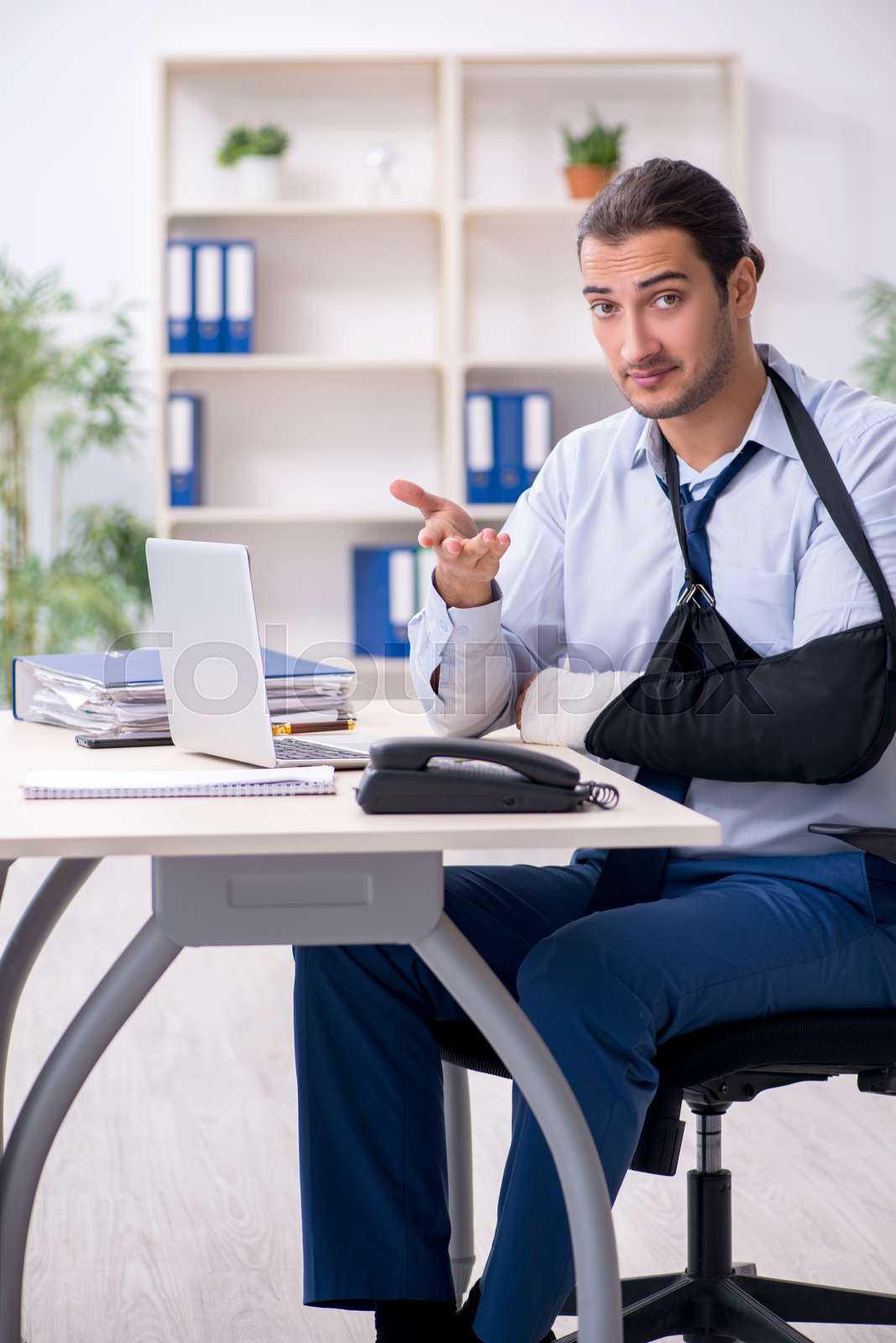 Injured male employee at workplace after accident | Stock image | Colourbox