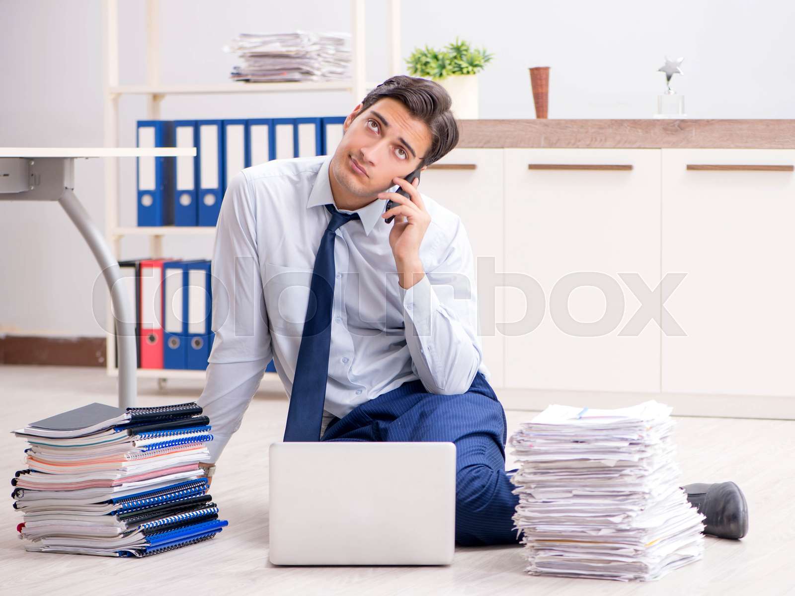 Extremely busy employee working in the office | Stock image | Colourbox