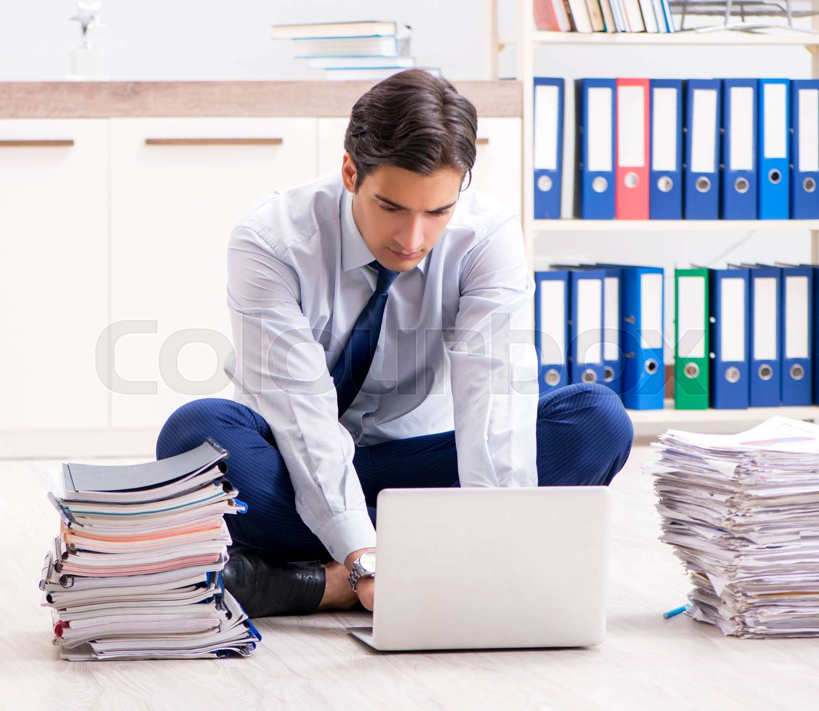Extremely busy employee working in the office | Stock image | Colourbox