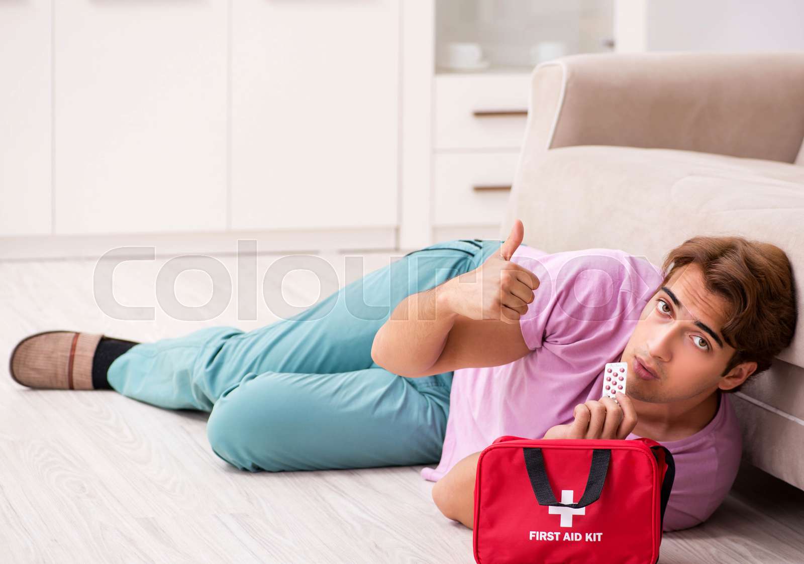 Sick man at home with first aid kit | Stock image | Colourbox