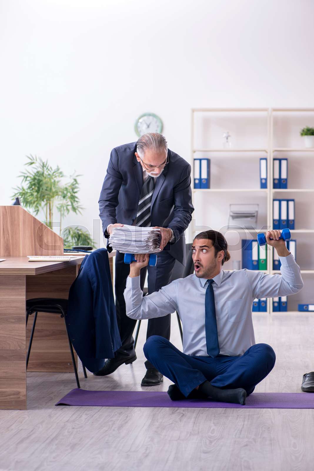 Two employees doing physical exercises at workplace | Stock image ...
