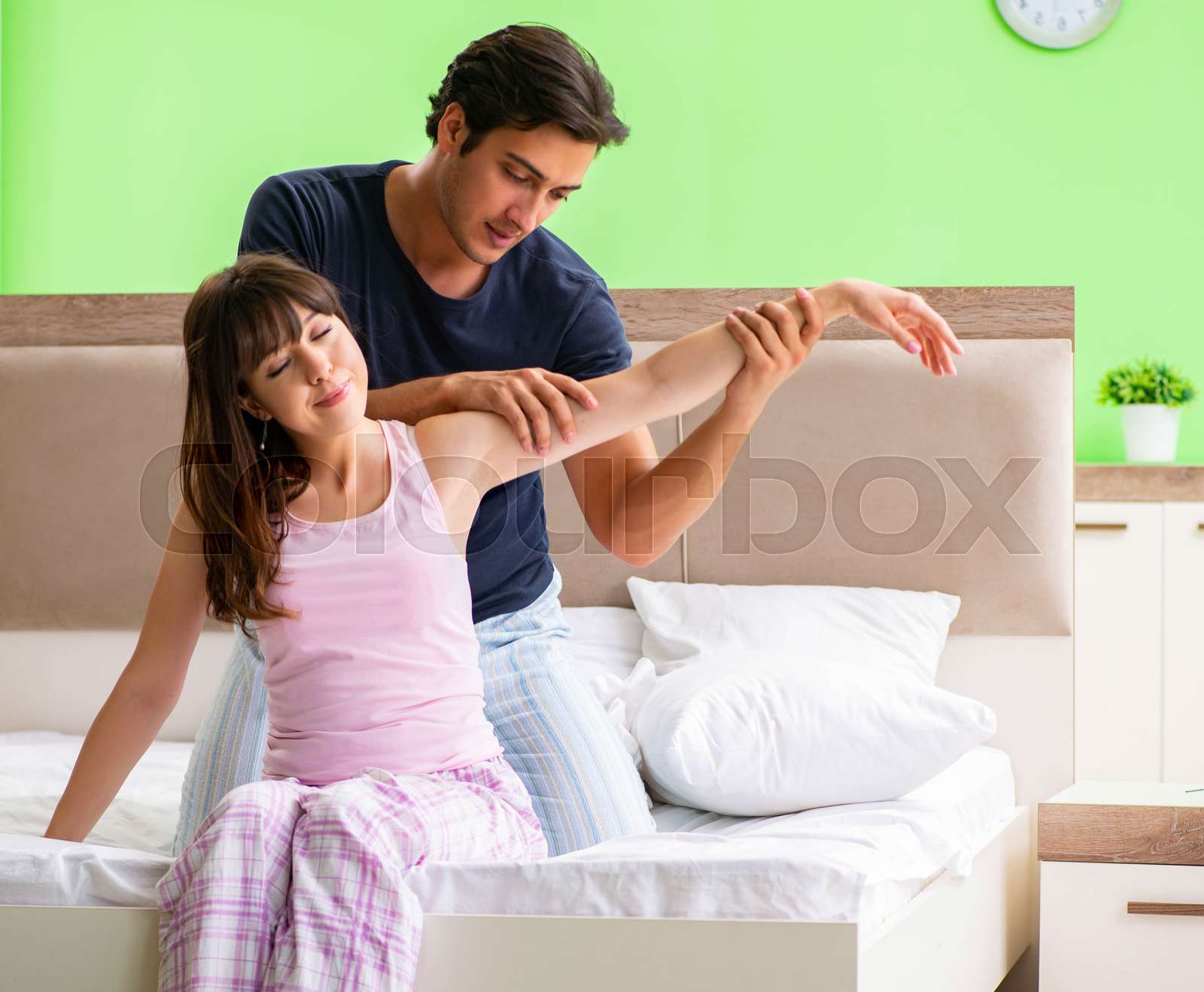 Man doing massage to his wife in bedroom | Stock image | Colourbox