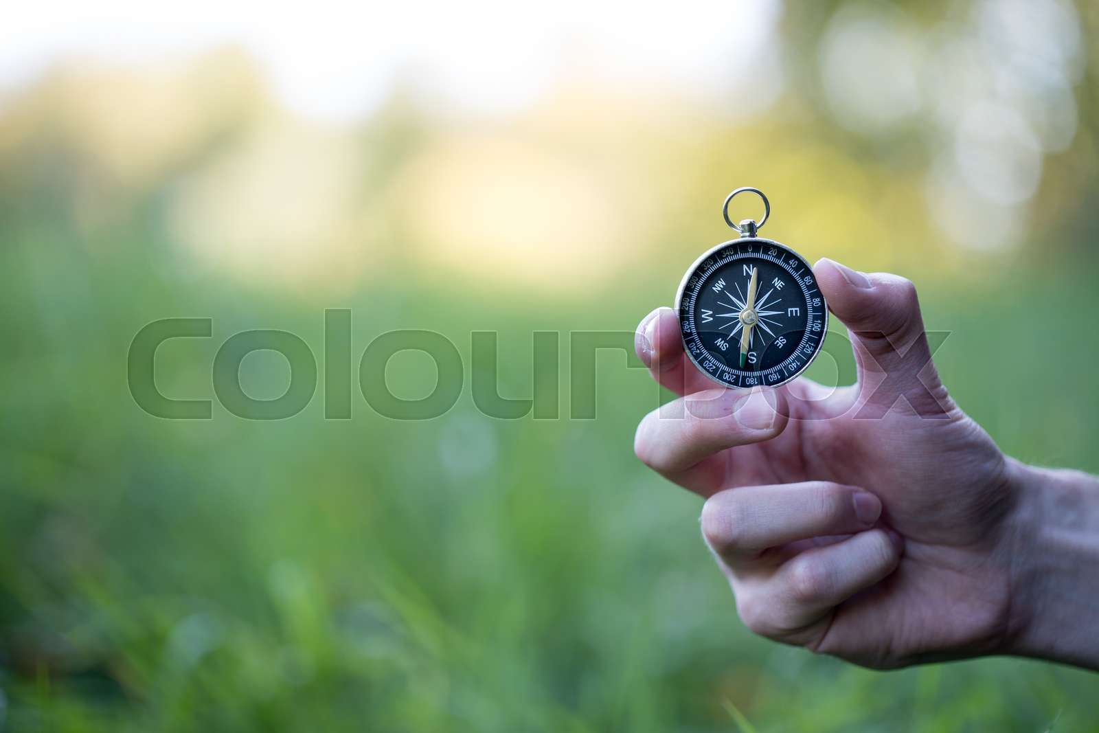 Compass holding in the hand, outdoor adventure | Stock image | Colourbox