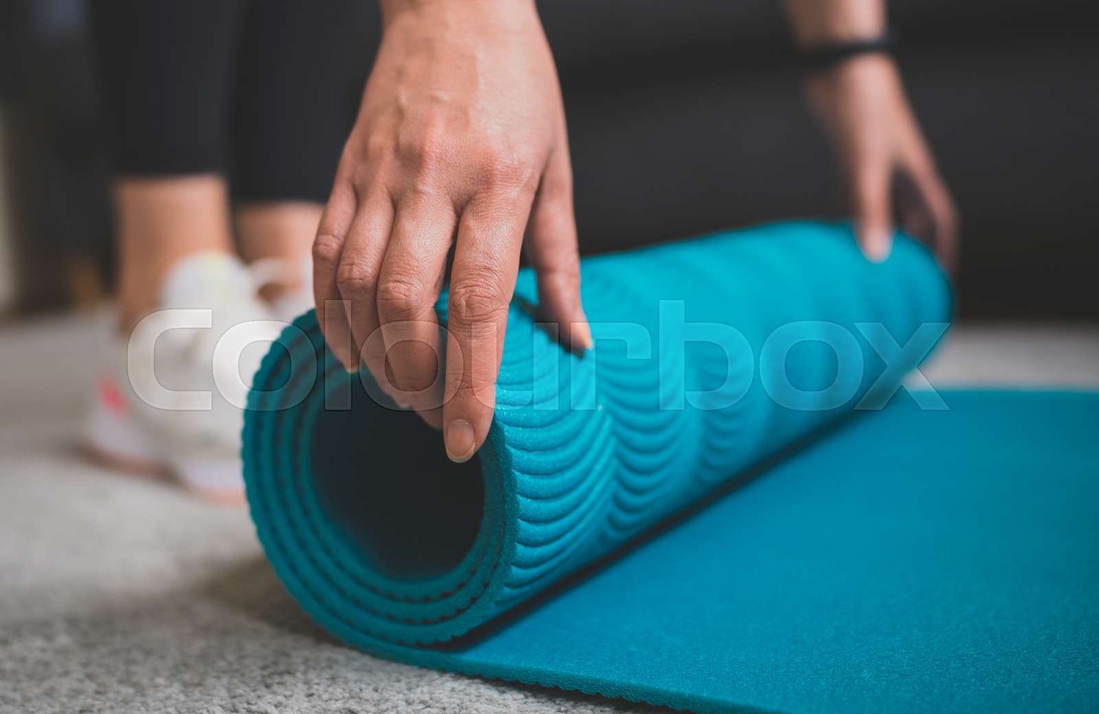 Woman rolling yoga mat. Home fitness training concept. | Stock image ...