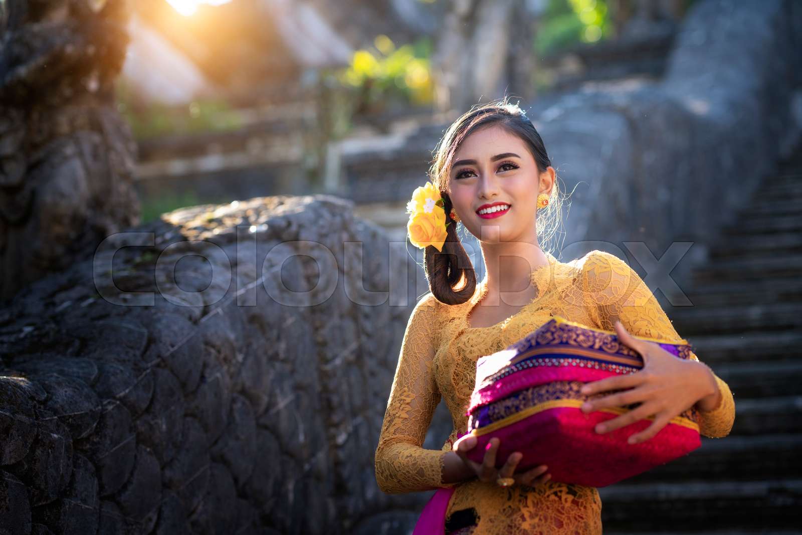 Bali Lady in Traditional dress walk in old temple | Stock image | Colourbox