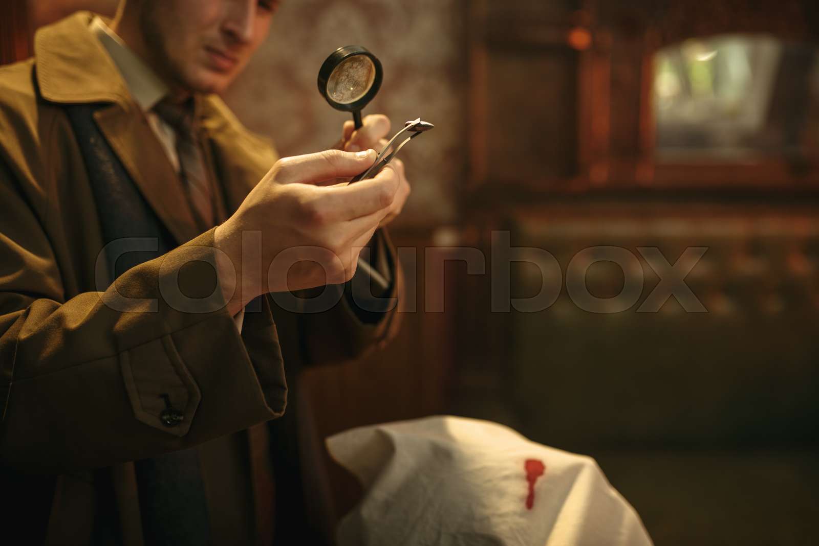 Detective looks evidence through magnifying glass | Stock image | Colourbox