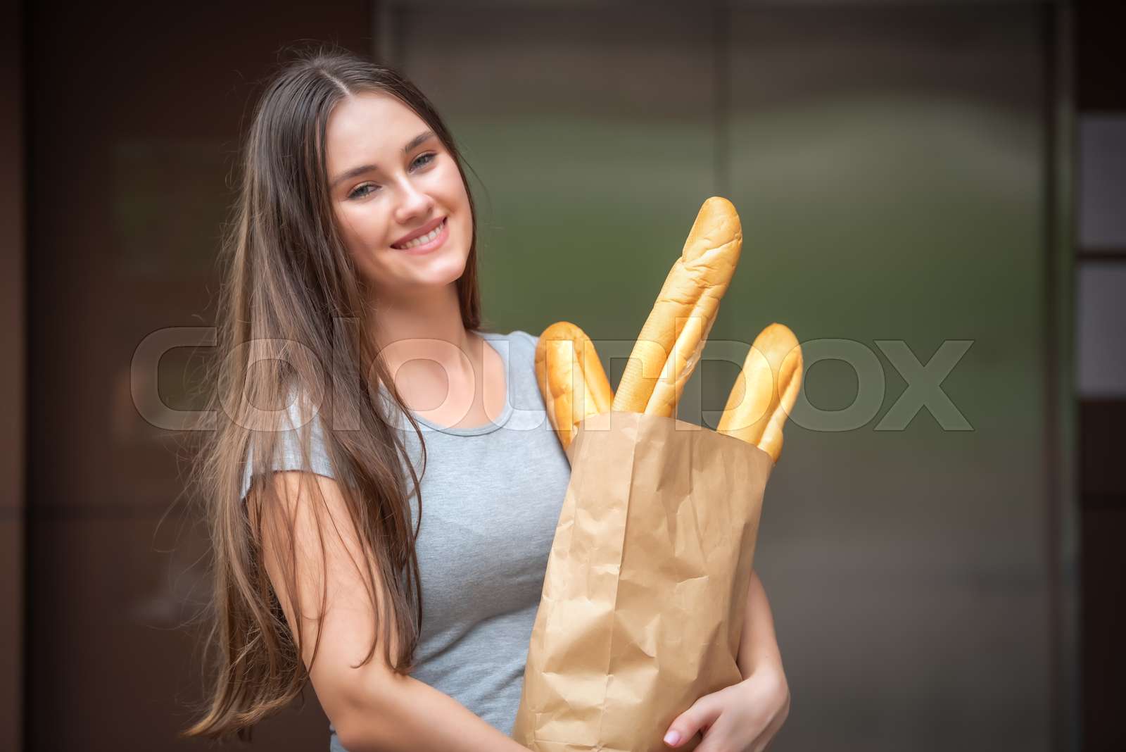 Woman receiving food package from delivery service company staff at ...