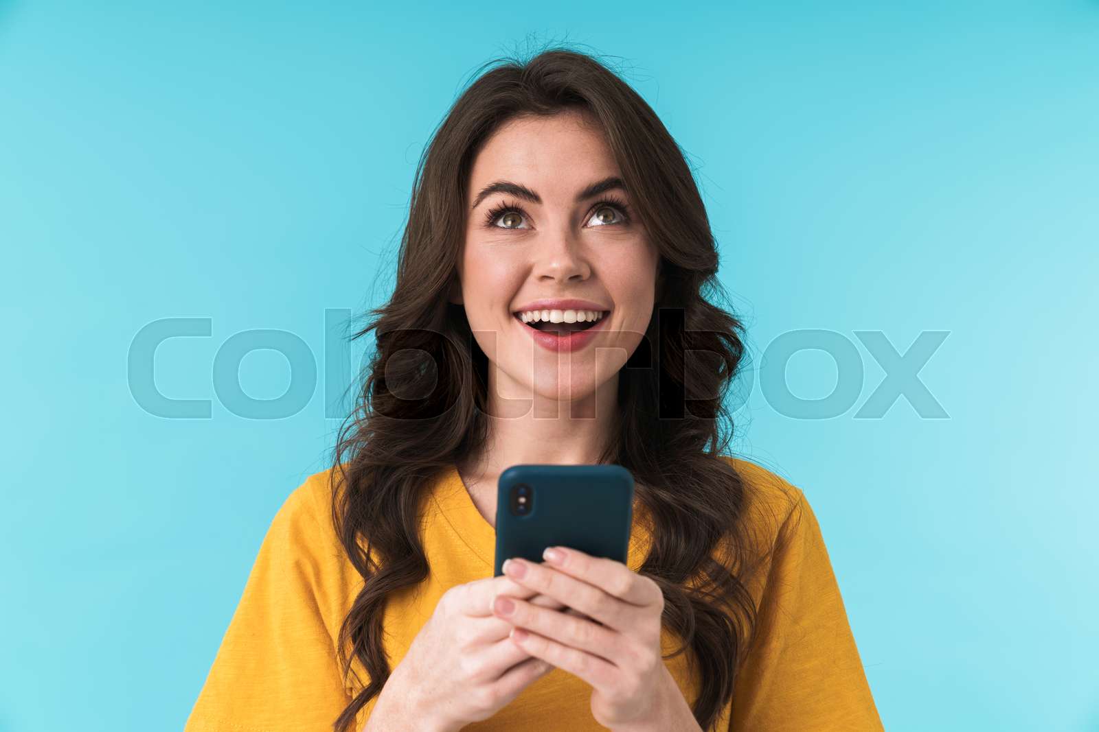 Smiling young girl using mobile phone. | Stock image | Colourbox