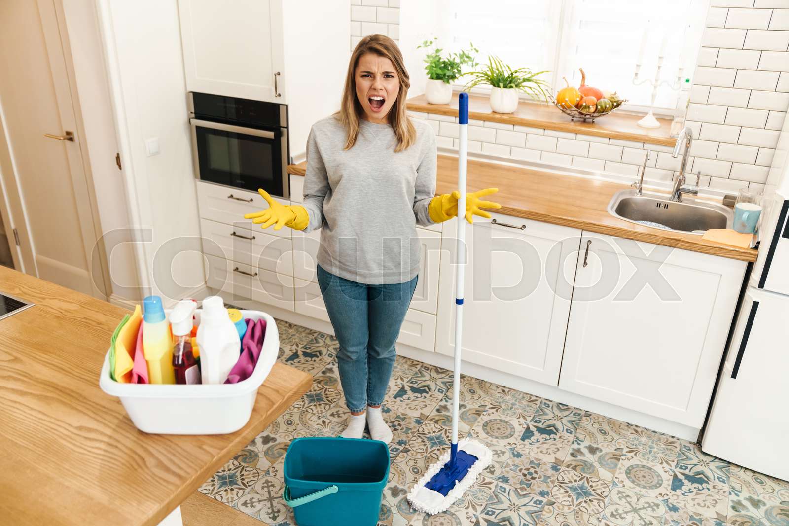 Photo of irritated woman housewife screaming while mopping floor | Stock image | Colourbox