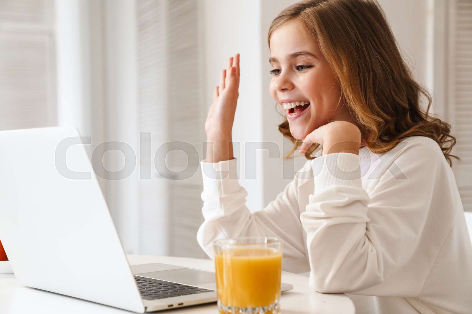 Photo of cheerful girl taking video call on laptop and waving hand ...