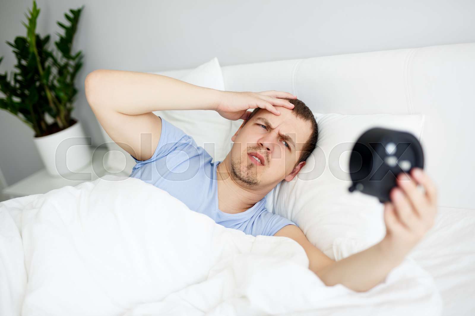 sleepy man waking up early after hearing alarm clock signal | Stock ...
