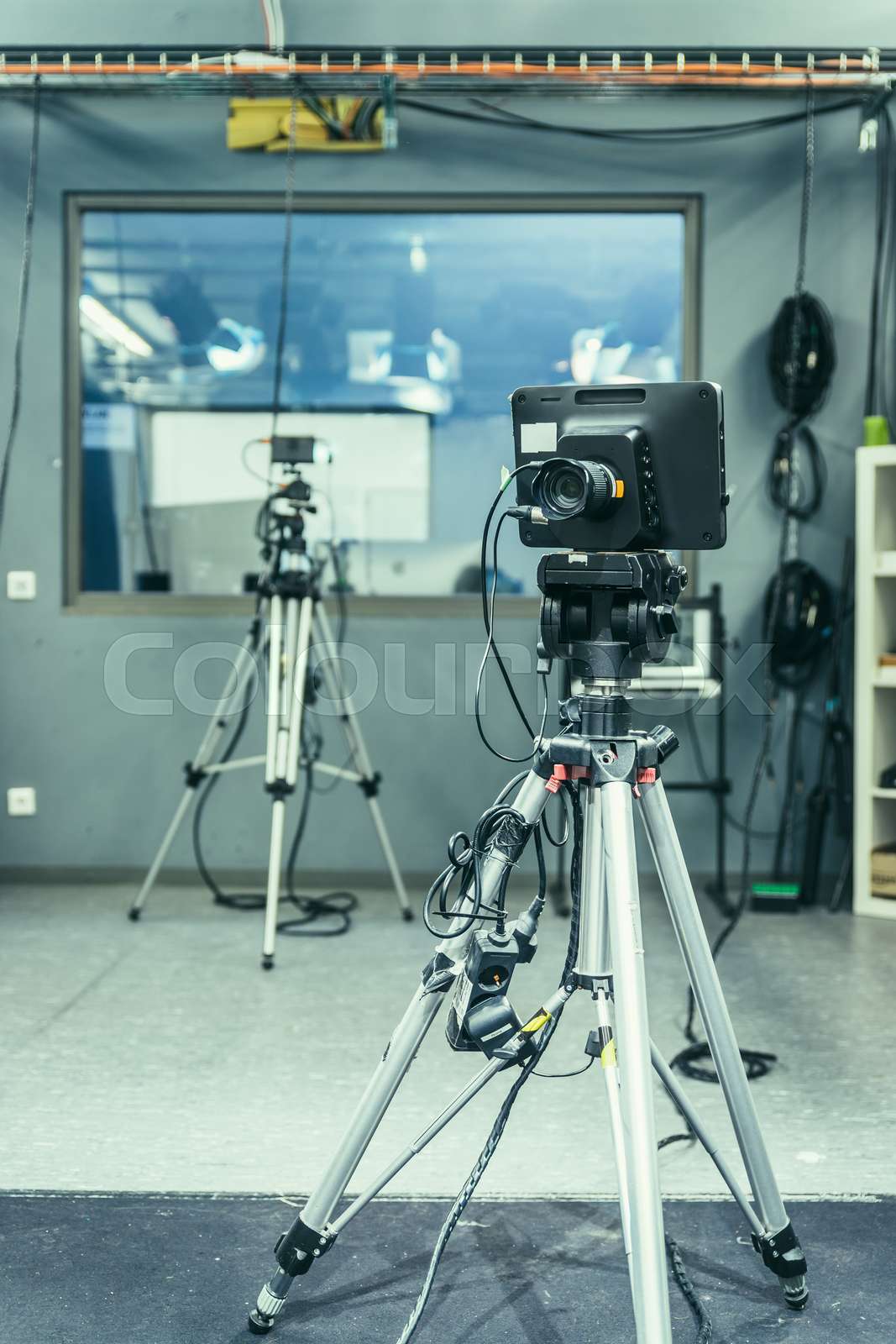 Film camera in broadcasting studio, spotlights and other equipment ...