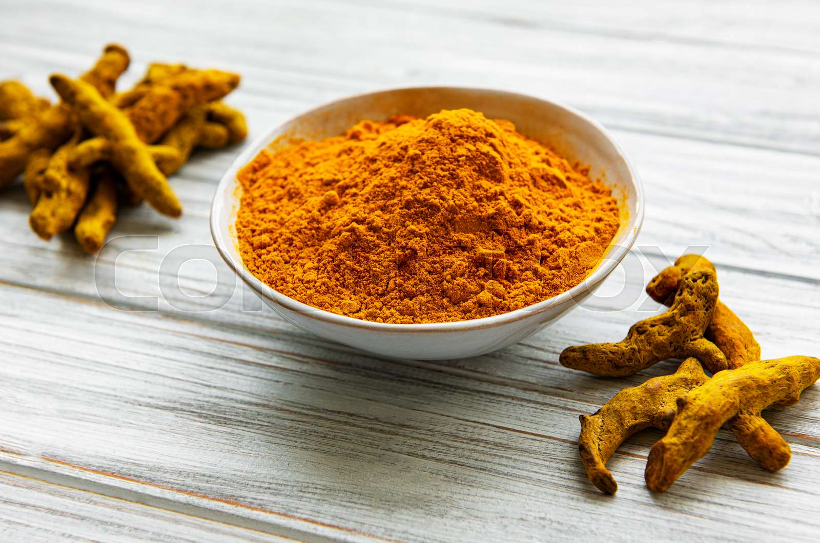 Yellow turmeric powder and dry roots | Stock image | Colourbox