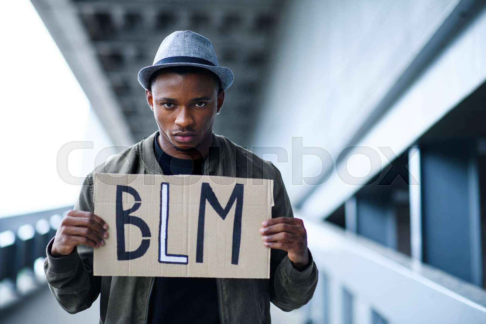 Man with BLM sign standing outdoors, black lives matter concept ...