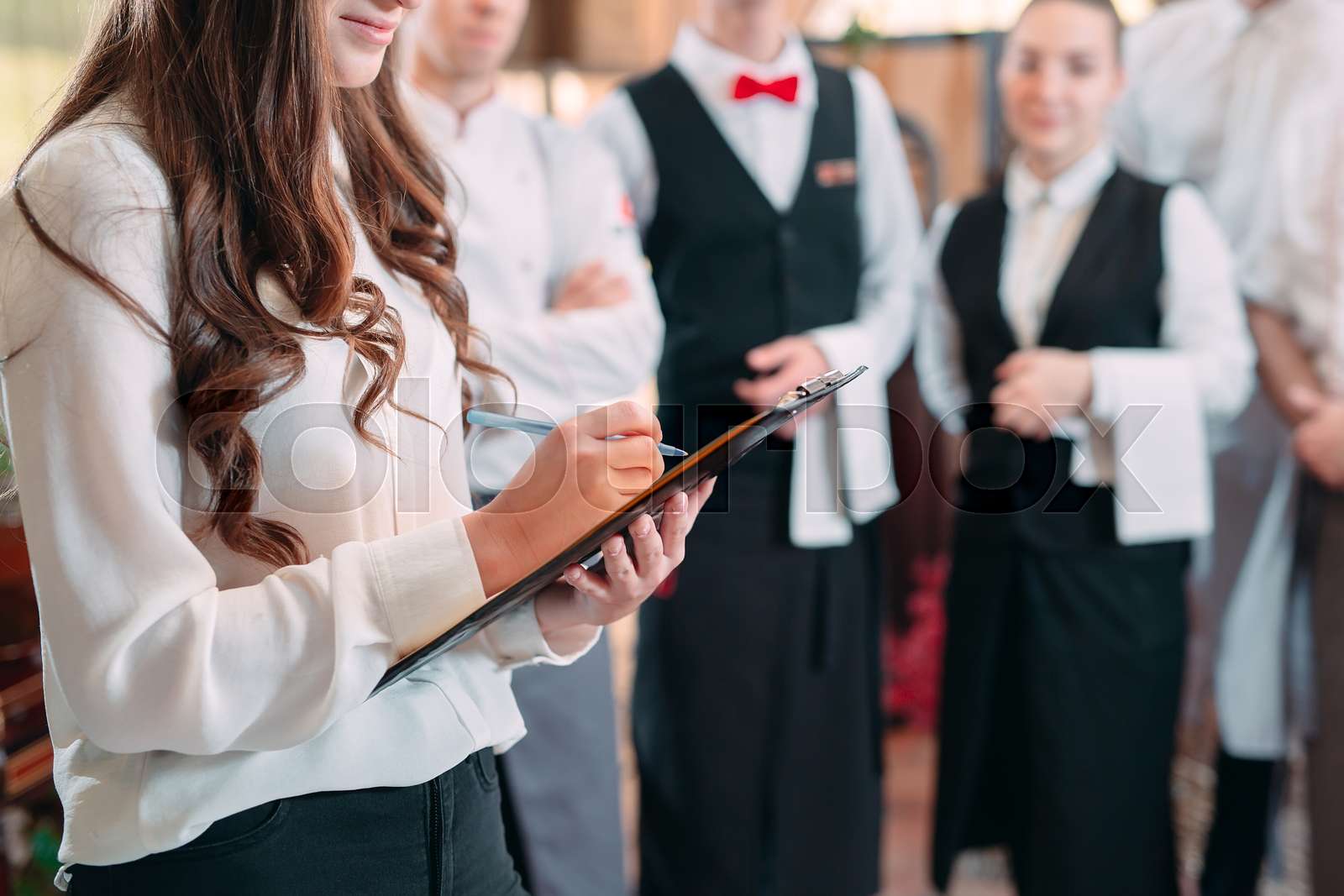 restaurant manager and his staff in kitchen. interacting to head chef ...