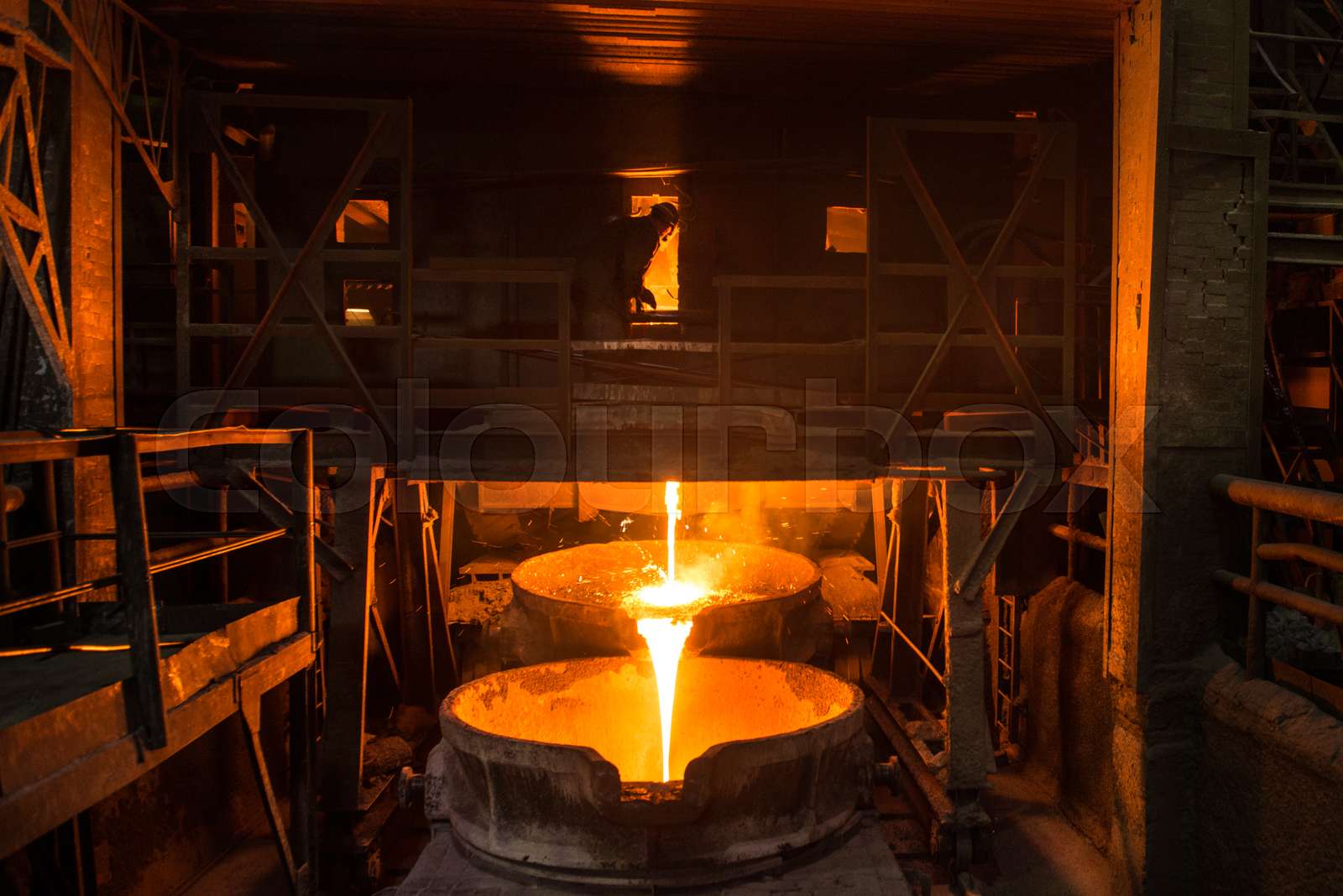 Steelworker at work near arc furnace and pouring liquid metal | Stock ...