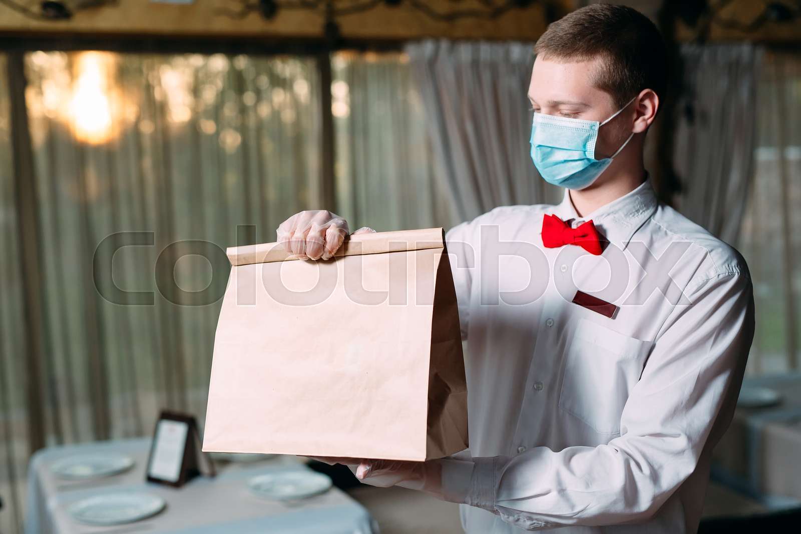Food delivery from the restaurant. Portrait of a waiter holding a craft ...