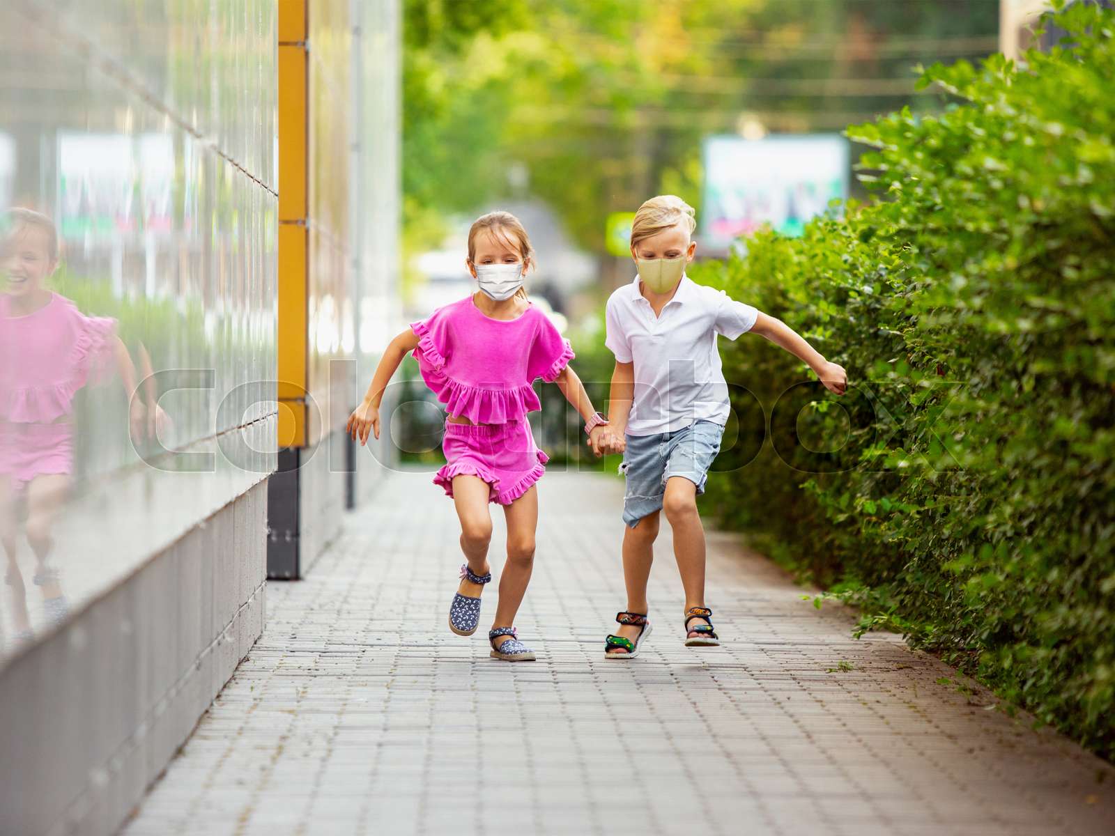 Happy little caucasian kids jumping and running on the city street ...