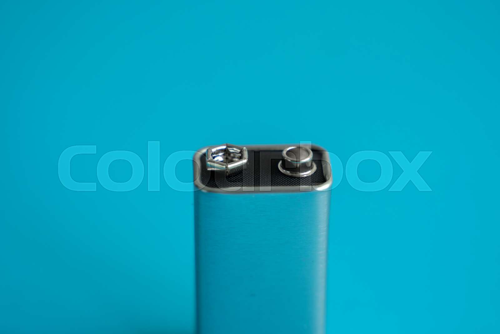 High voltage battery on a blue background. Silver Volt battery. 9V ...