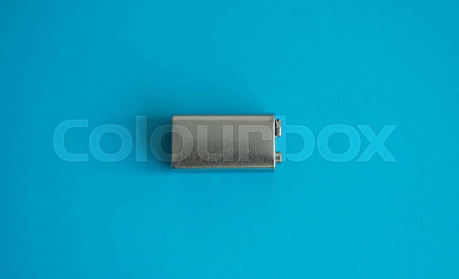High voltage battery on a blue background. Silver Volt battery. 9V ...