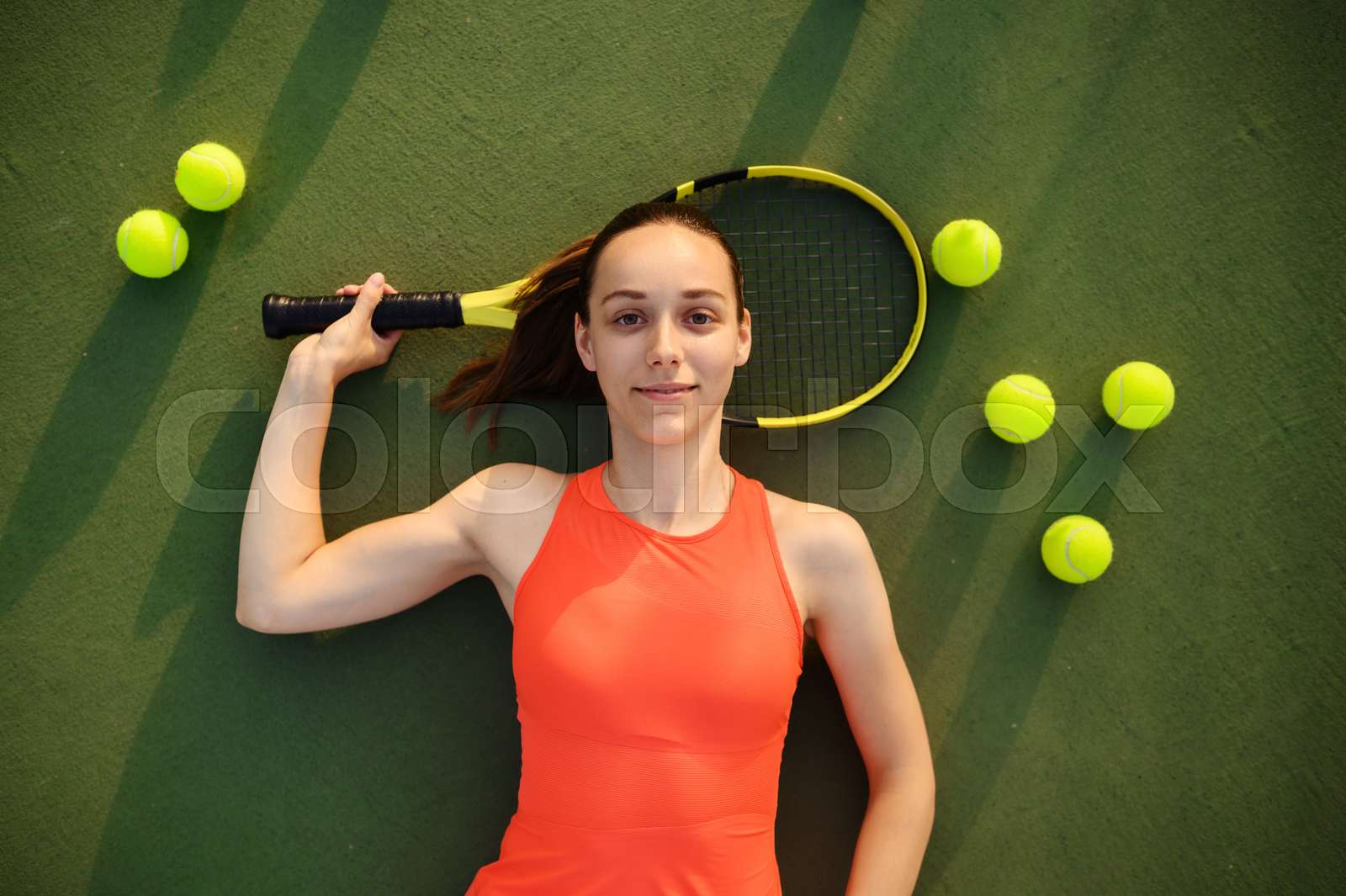 Tired female tennis player lies on court | Stock image | Colourbox