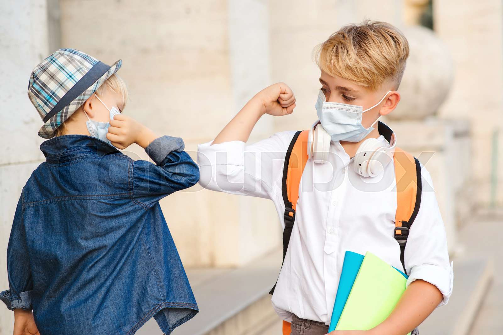 Children with face mask going back to school. New greeting style. Kids ...