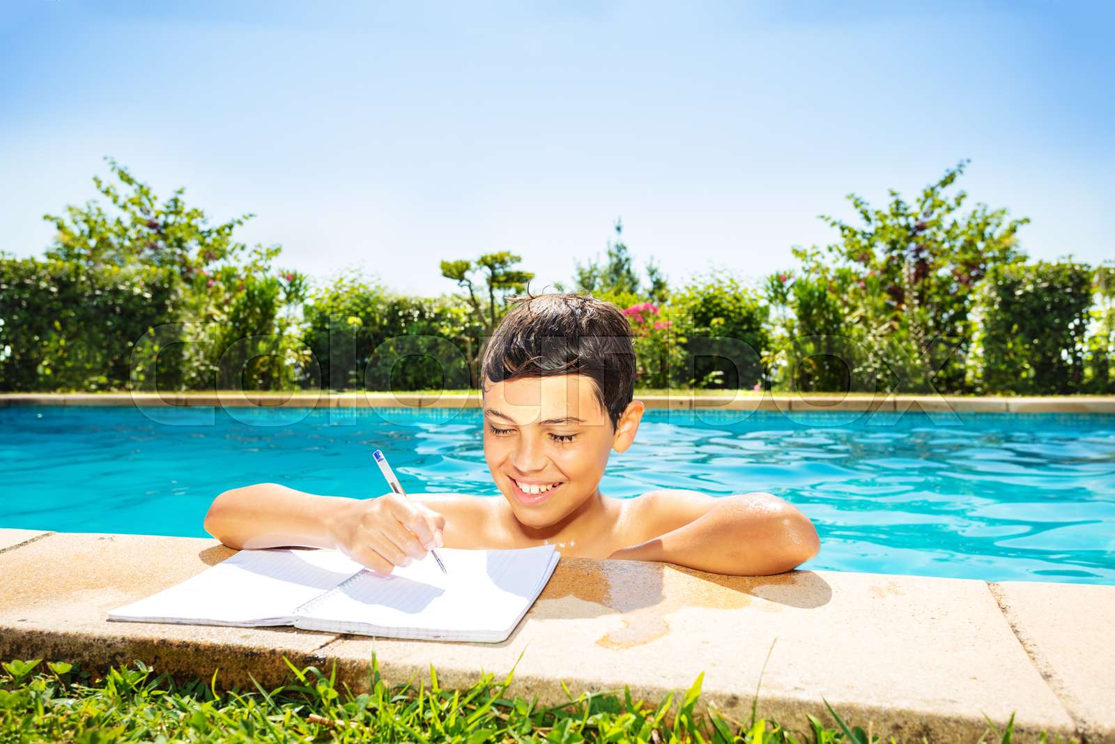 Homework can be fun boy with textbook in the pool | Stock image | Colourbox