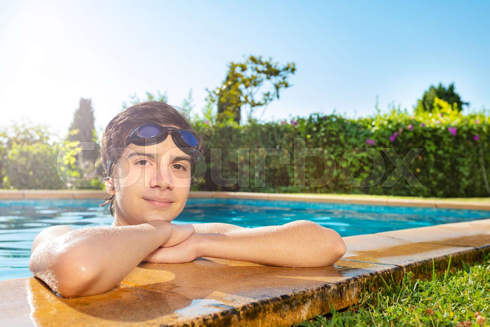 Handsome boy in swimming pool rest on border | Stock image | Colourbox