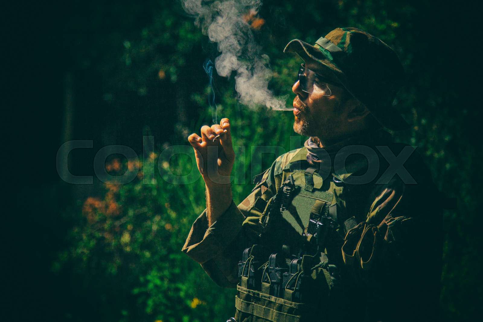 Army soldier smoking cigarette or joint at night | Stock image | Colourbox