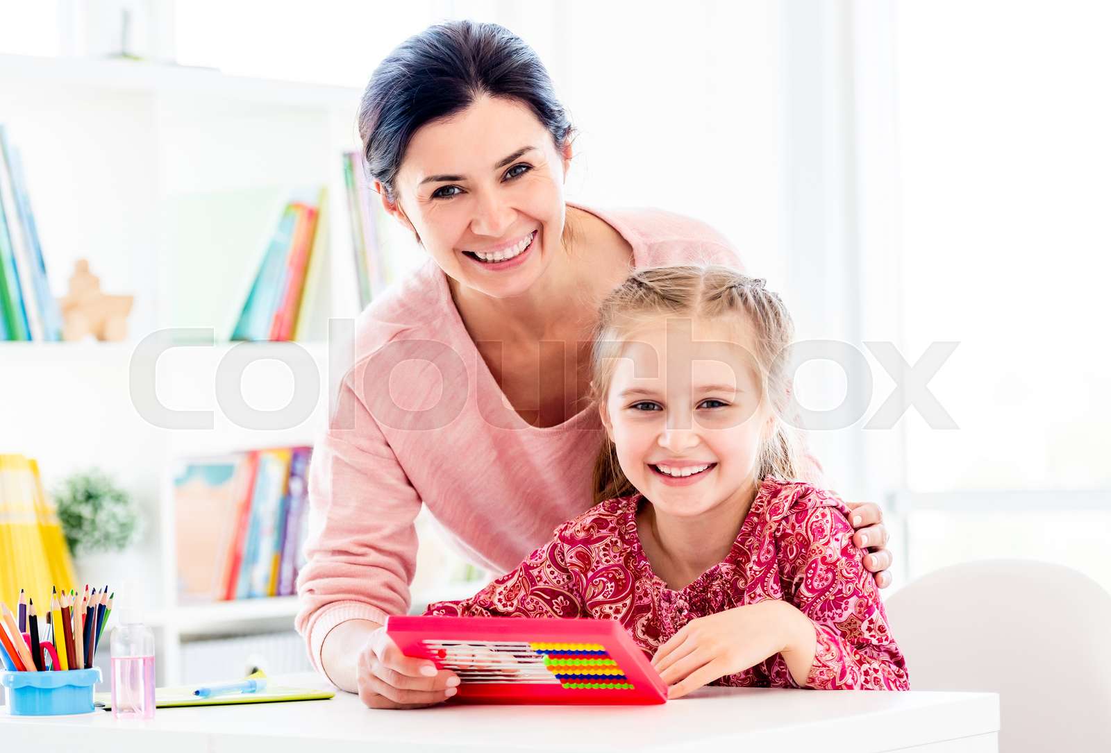 Smiling teacher and little girl during lesson | Stock image | Colourbox