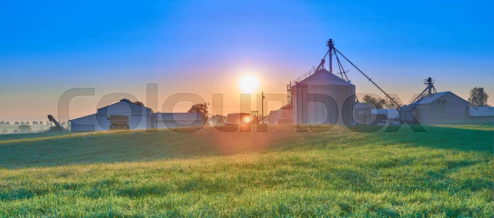 Sunrise Over Farm with Silo and blue Sky. | Stock image | Colourbox