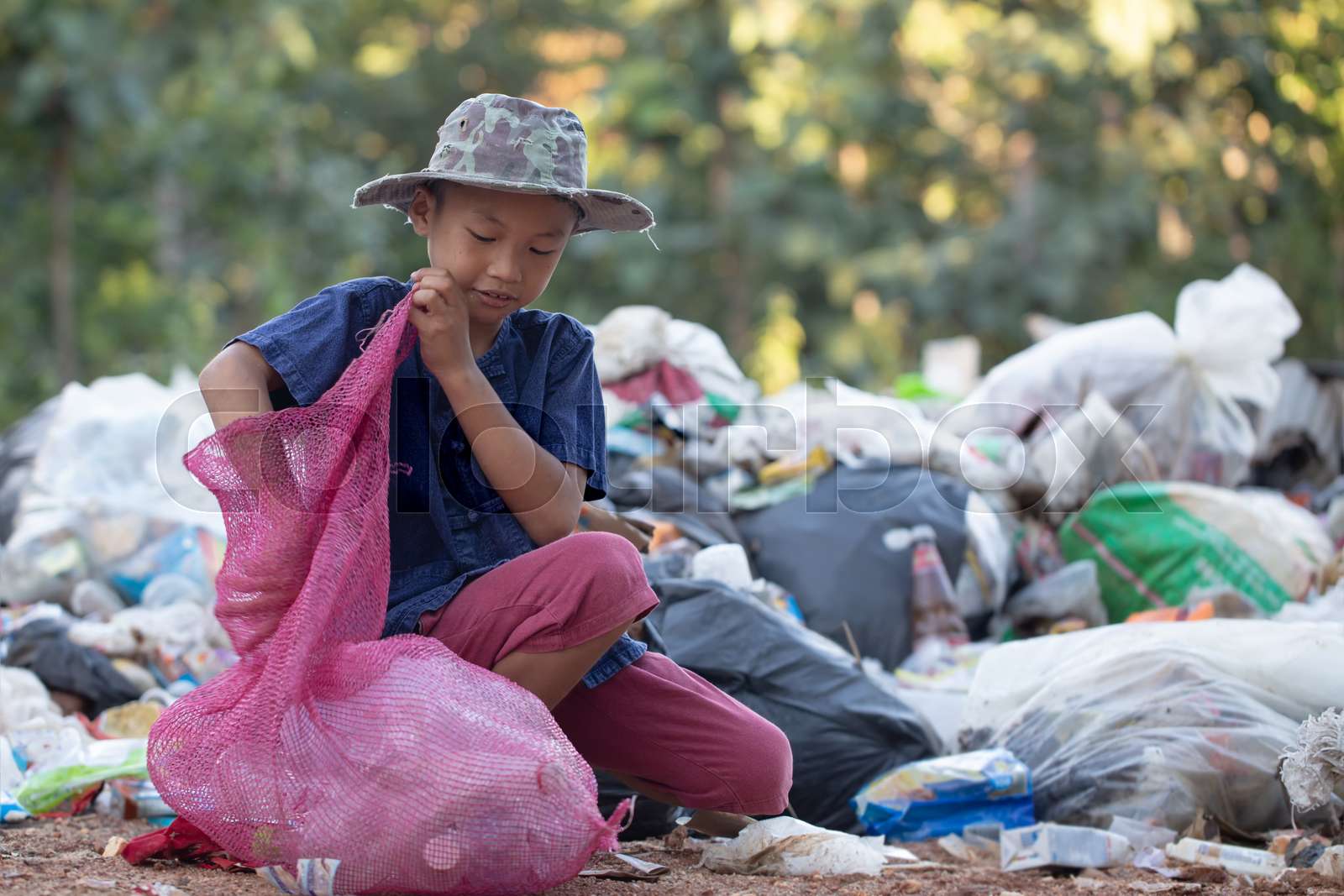 Poor boy collecting garbage in his sack to earn his livelihood, The ...