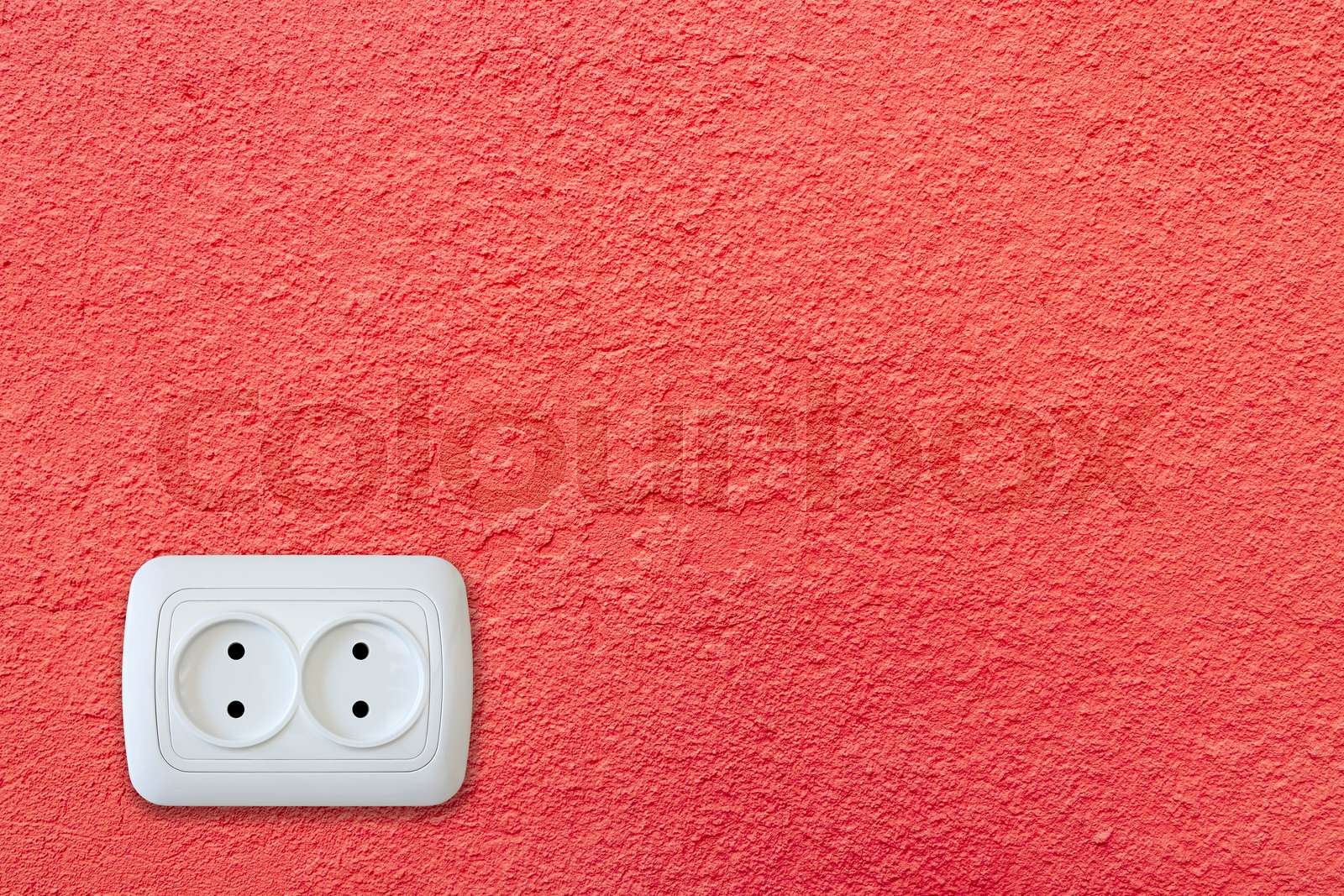 White electrical outlet socket on red wall | Stock image | Colourbox