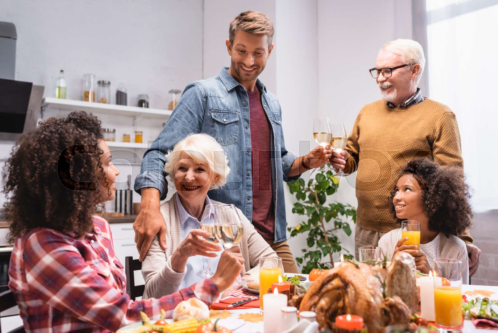 joyful multicultural family celebrating thanksgiving day at table ...