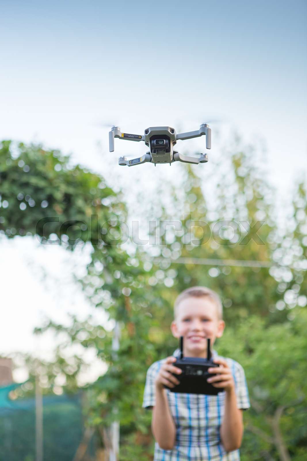 Kid flying drone. Boy operate drones | Stock image | Colourbox