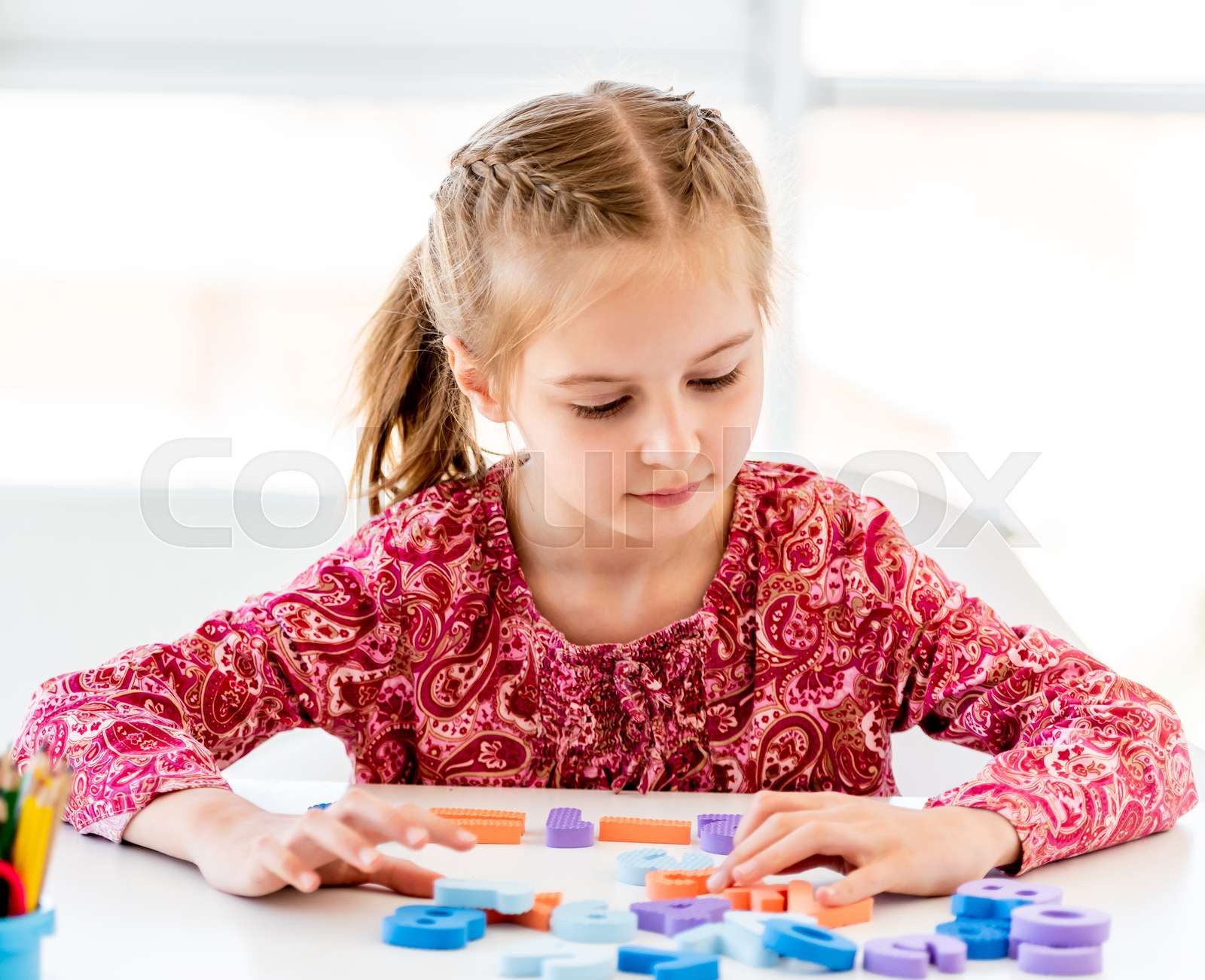 Little girl solving task at school | Stock image | Colourbox