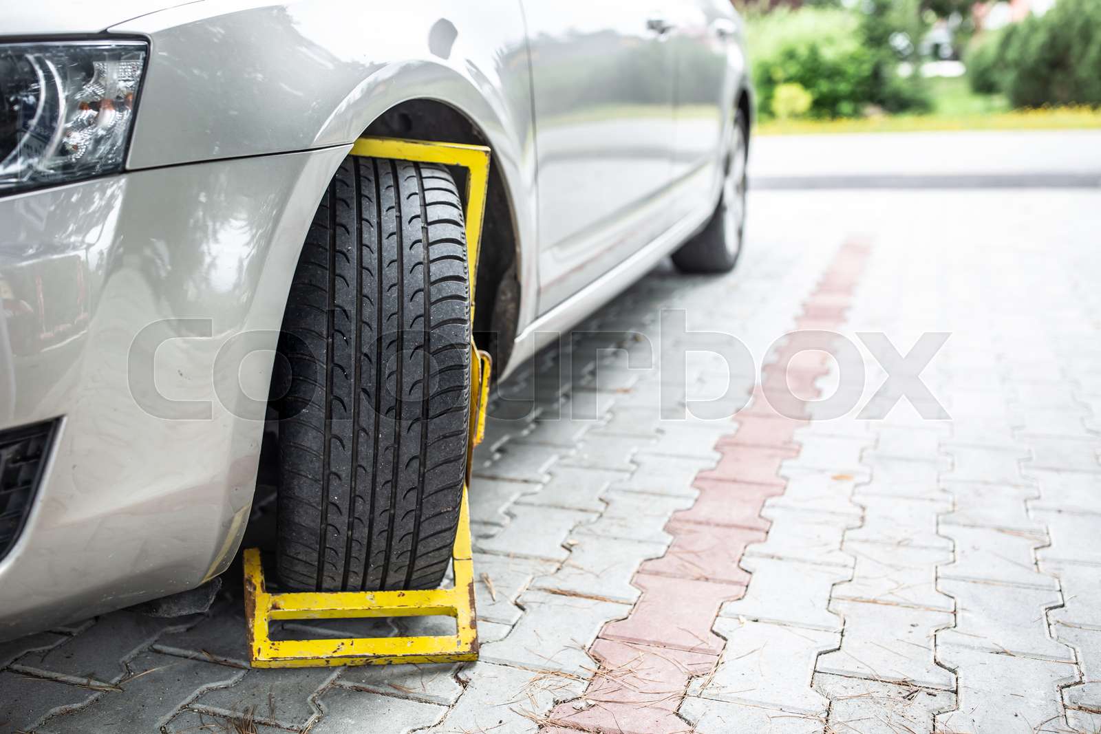 Yellow wheel clamp on an illegally parked car | Stock image | Colourbox Yellow wheel clamp on an illegally parked car | Stock image | Colourbox