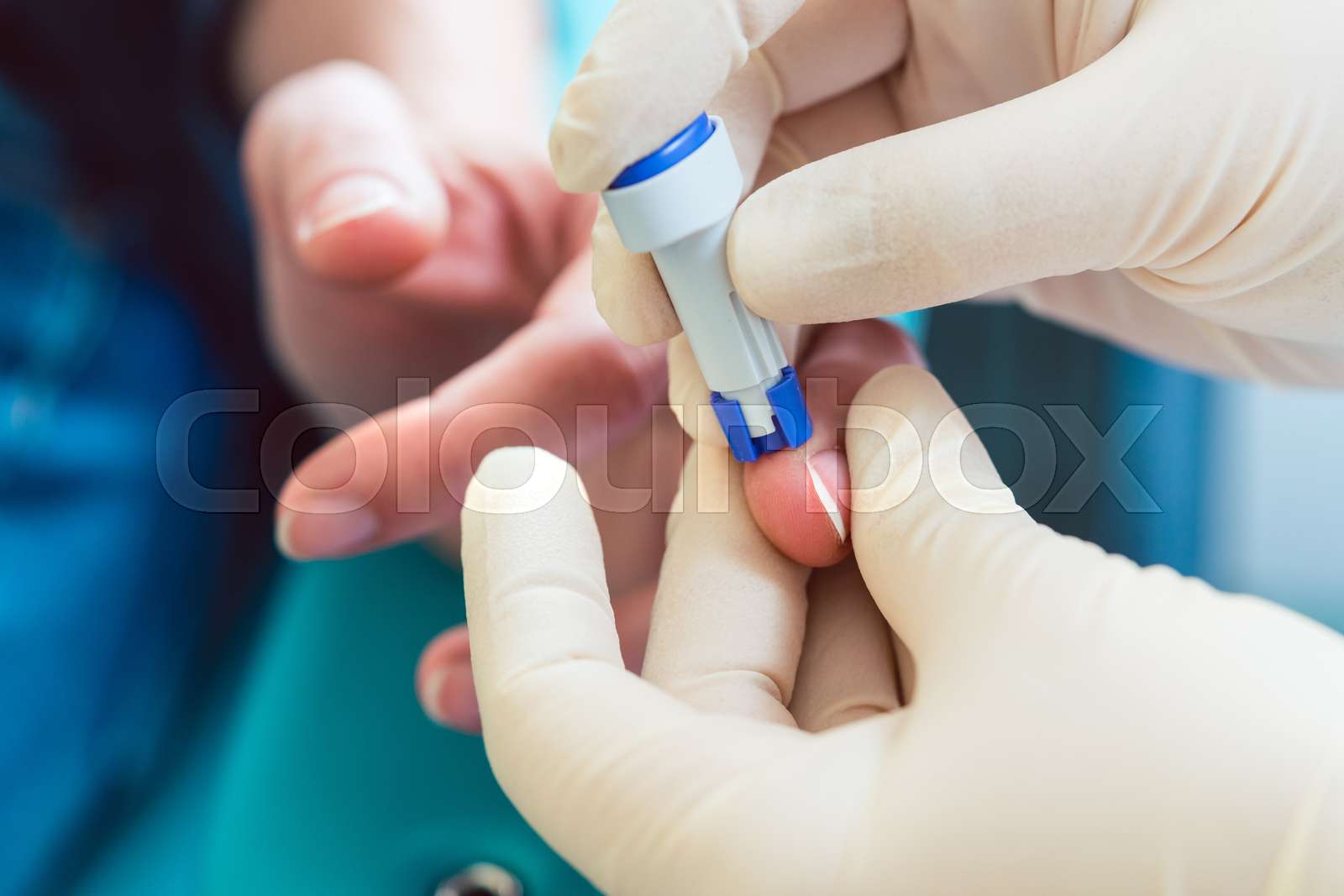 Nurse puncturing finger of patient to squeeze out blood sample for ...