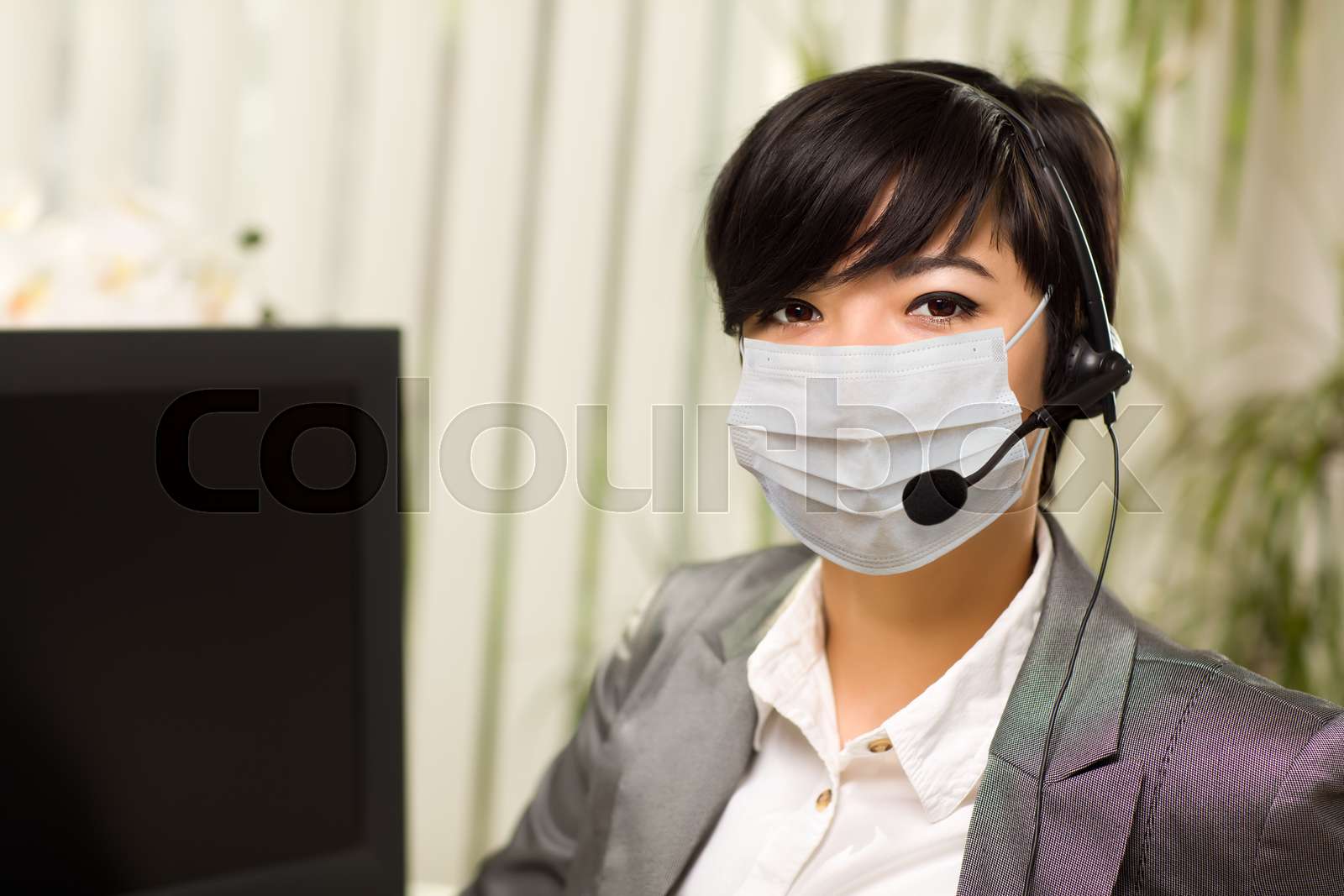 Woman At Office Desk Wearing Medical Face Mask | Stock image | Colourbox