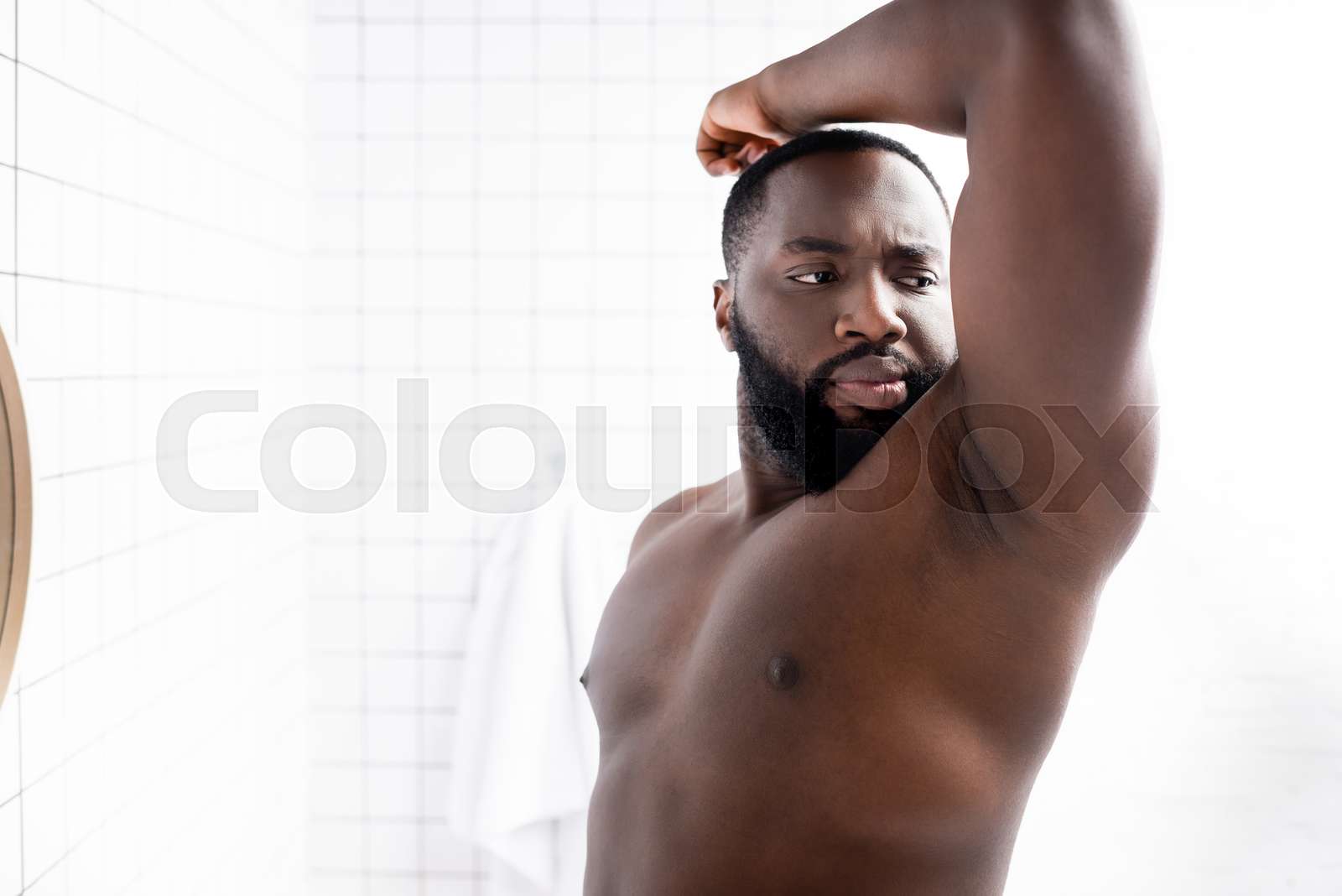 afro-american man putting hand up and smelling armpit | Stock image ...