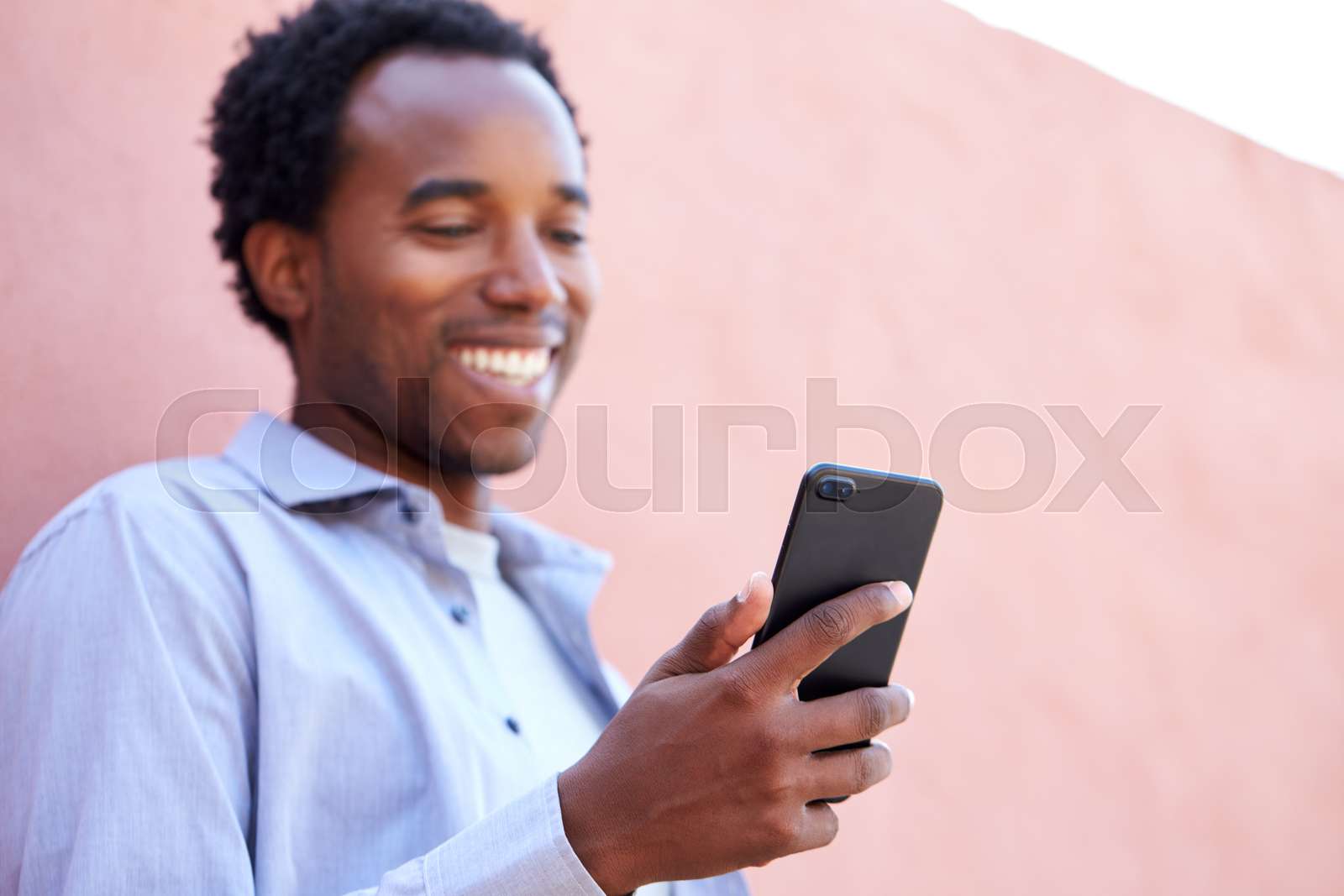 Outdoor Portrait Of Man Using Mobile Phone In The Street Leaning ...
