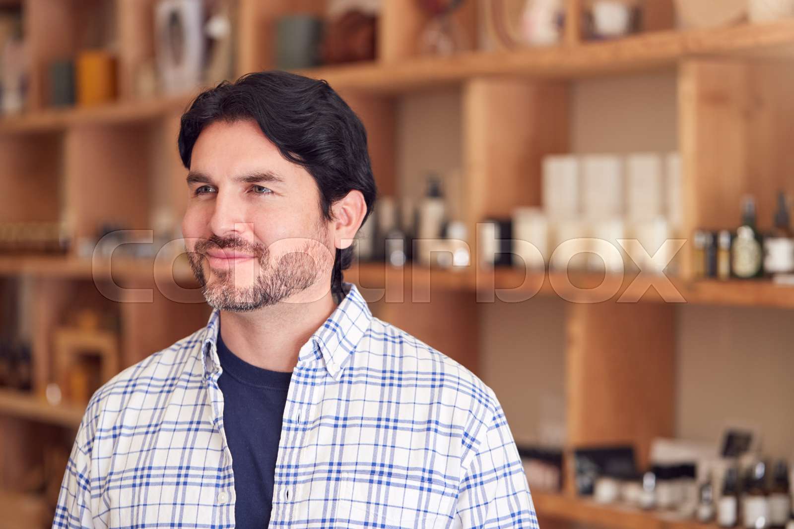 Male Owner Of Gift Store Standing In Front Of Shelves With Cosmetics ...
