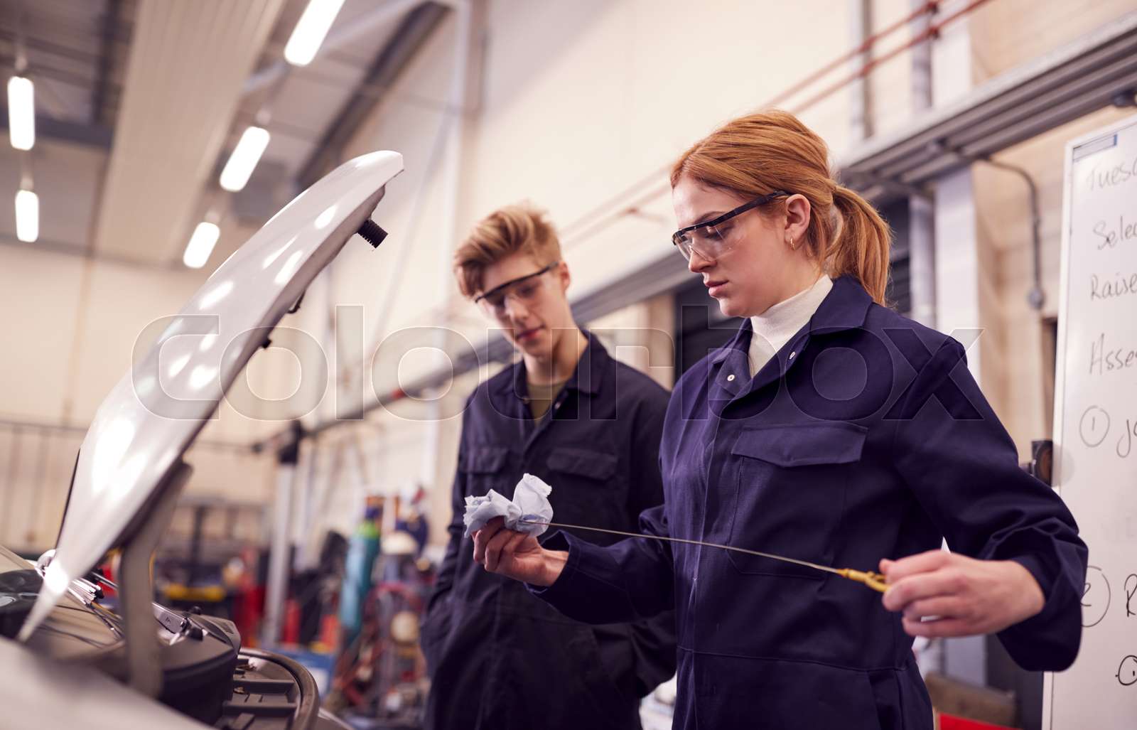 male-and-female-students-checking-car-oil-level-on-auto-mechanic